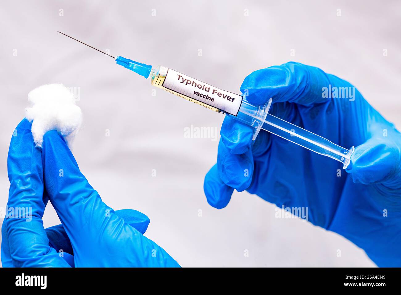 The picture shows a doctor holding a syringe with the typhoid fever ...