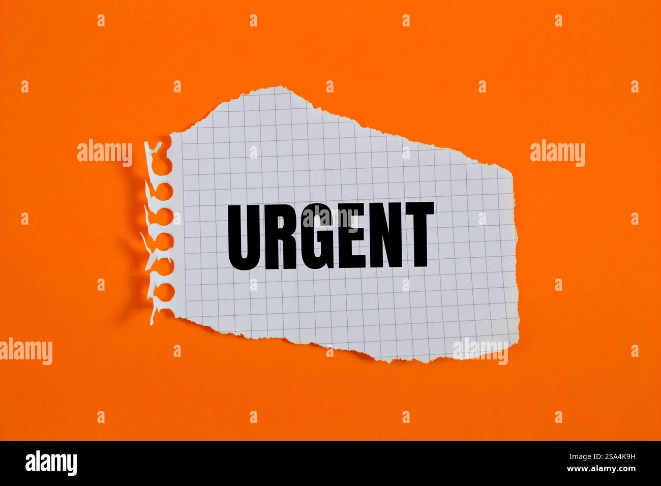 Urgent message written on ripped torn checkered graph paper piece with ...