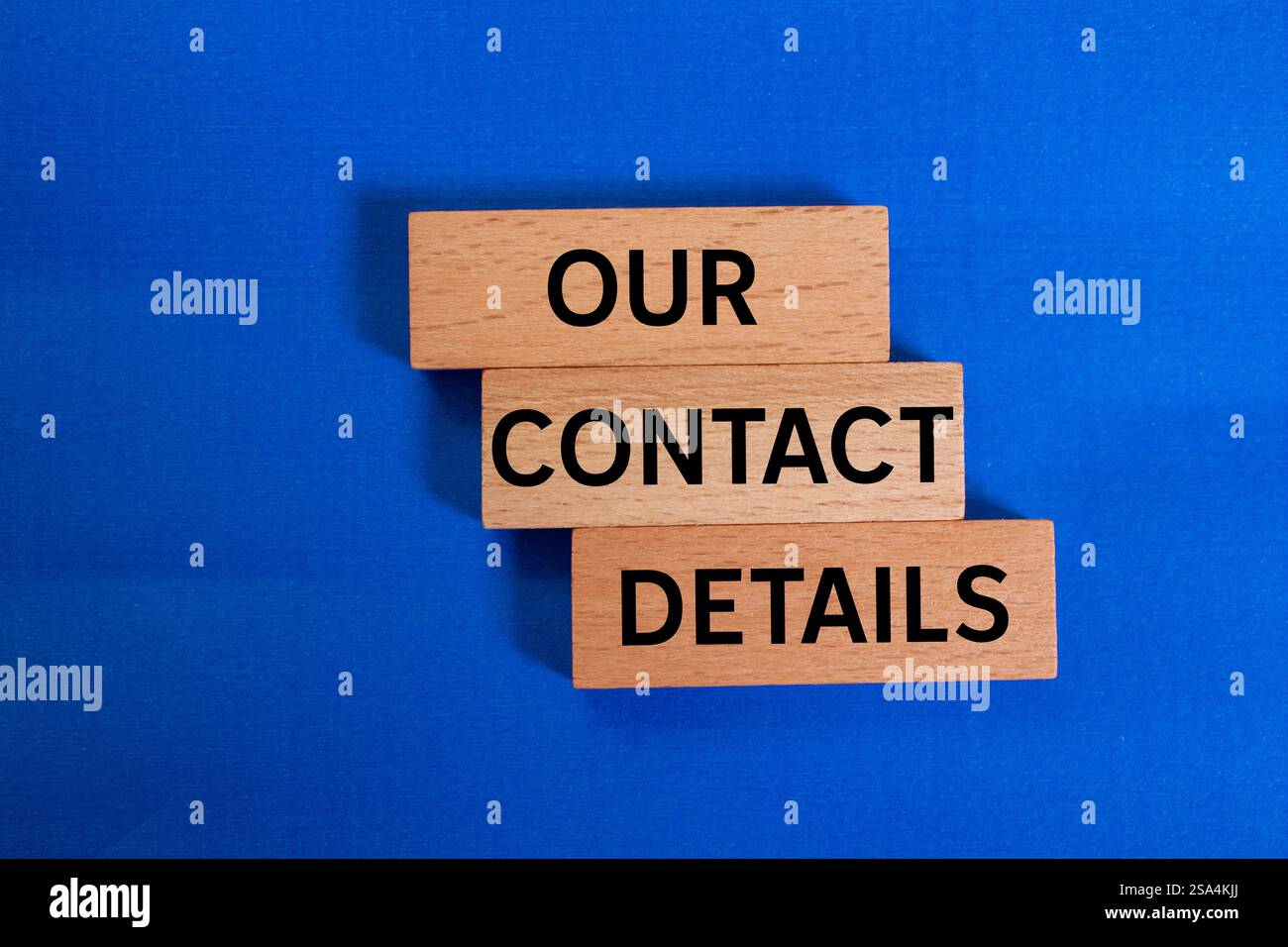 Our contact details message written on wooden blocks on blue background. Conceptual our contact ...
