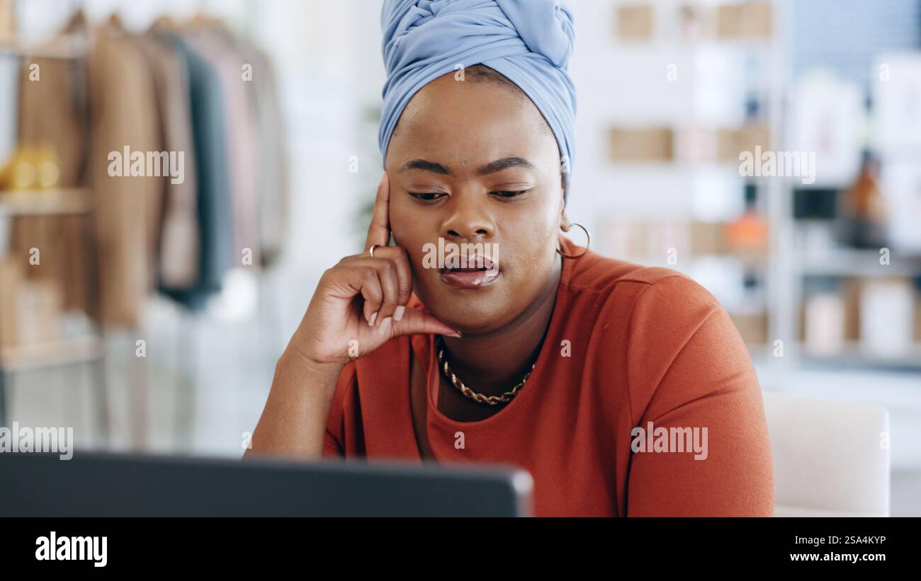 Thinking, designer and serious black woman on laptop in office ...