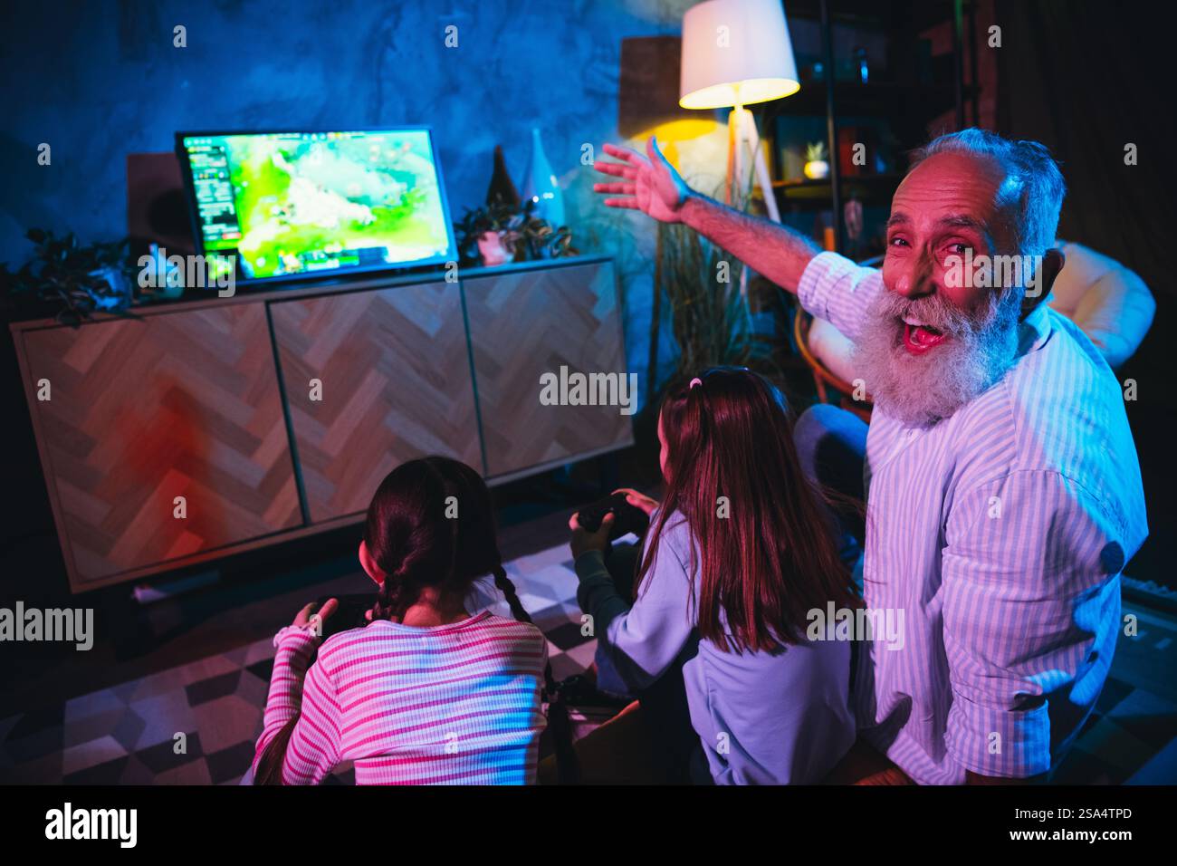Family bonding moment with grandfather and kids playing video games ...