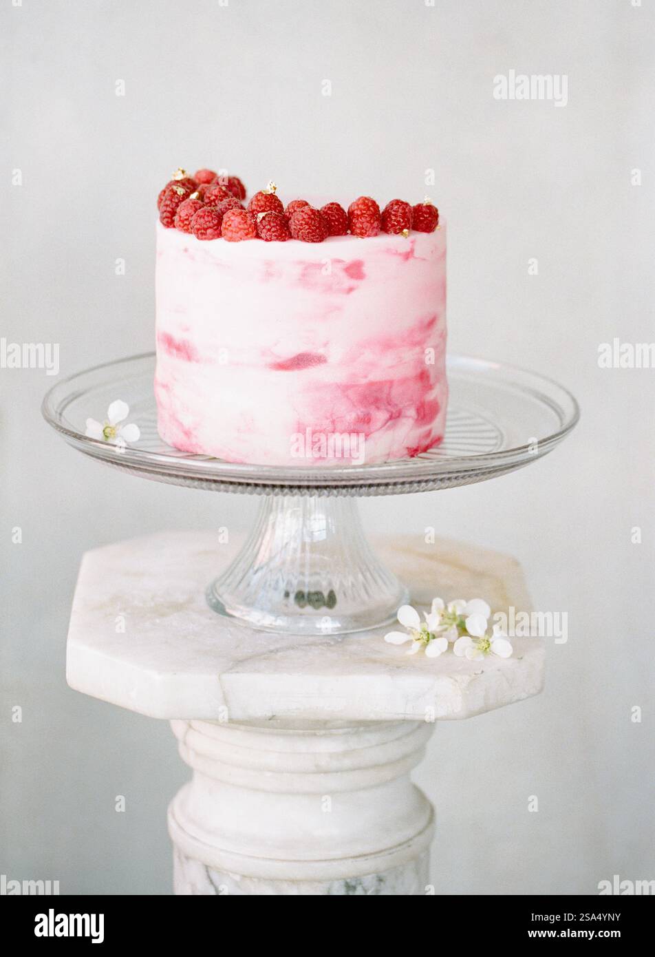 Stunning raspberry cake beautifully displayed on a glass stand with ...