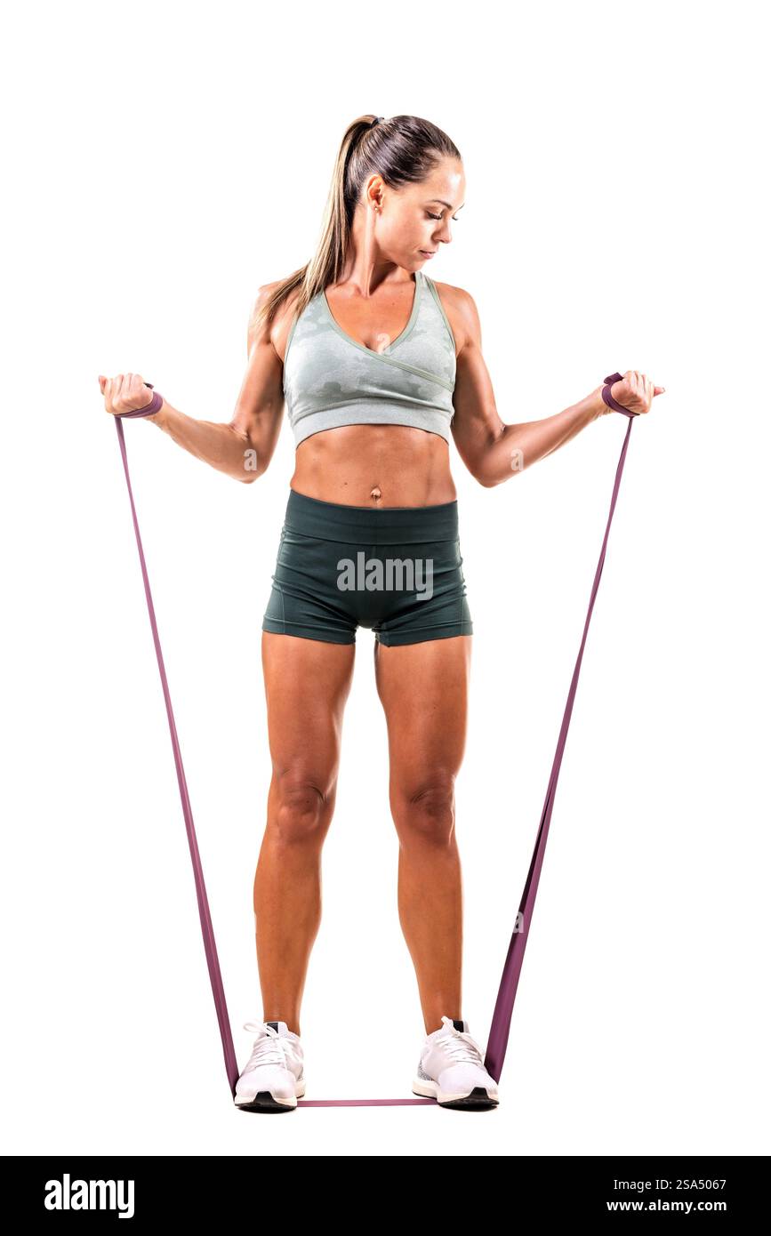 A fit woman performs resistance training exercises using a pink ...