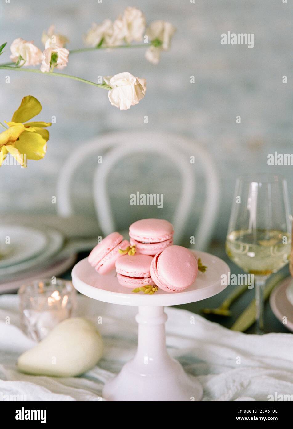 Elegant dessert display of pink macarons on a pedestal with floral ...