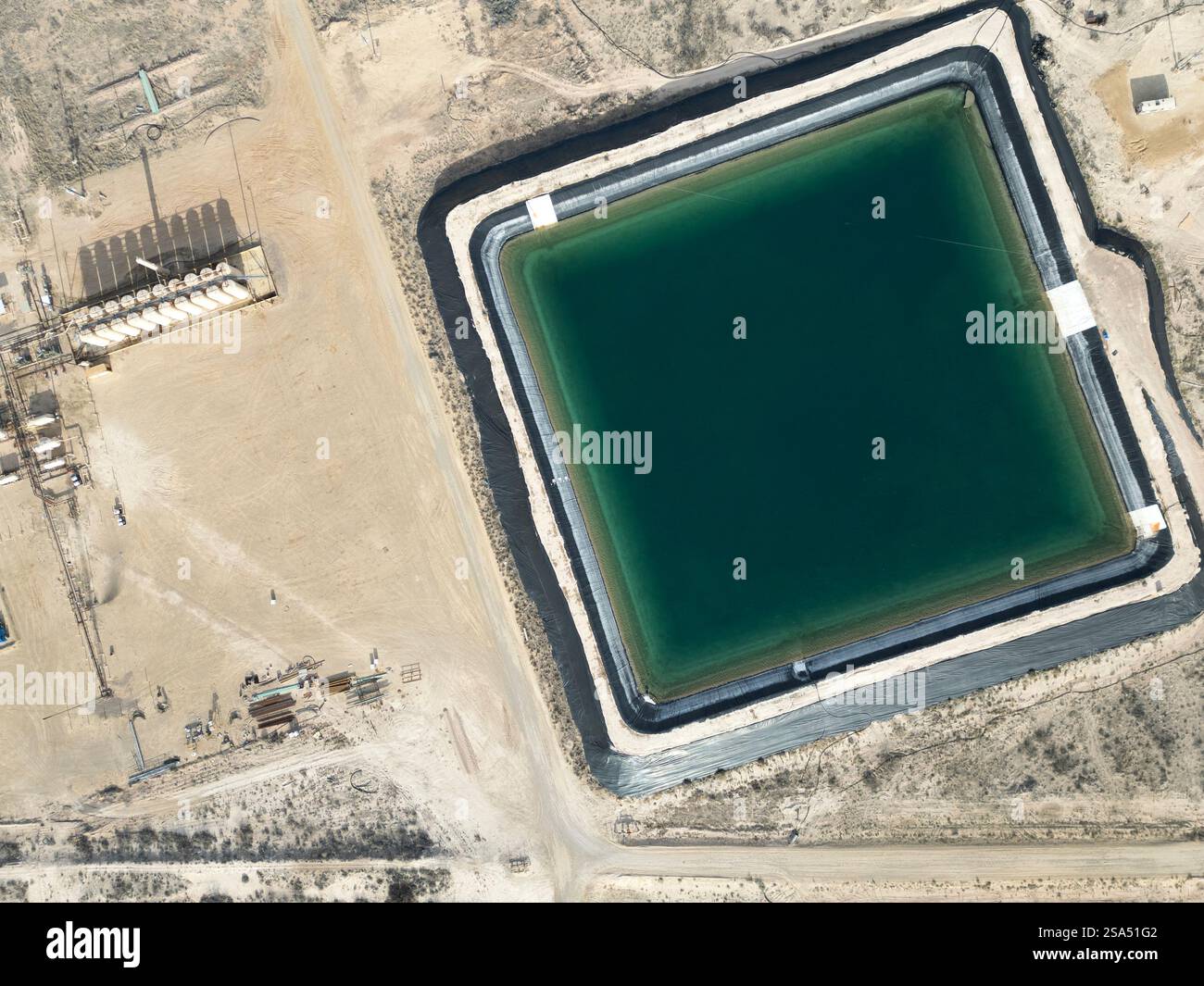 Aerial view looking down on a square water retention pond used in oil production and fracking in ...
