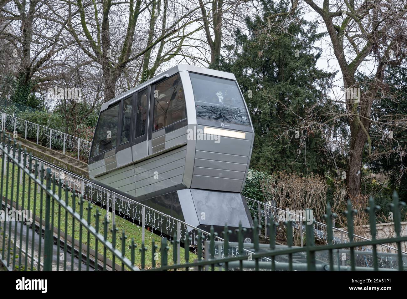 Modern funicular ascending a steep hill surrounded by lush trees Stock ...