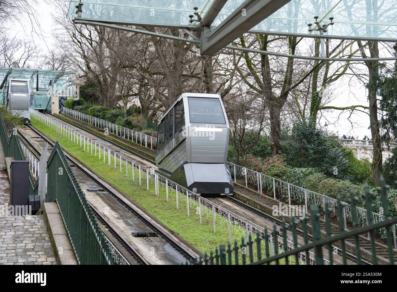 Modern funicular railway ascending a green hillside in an urban ...