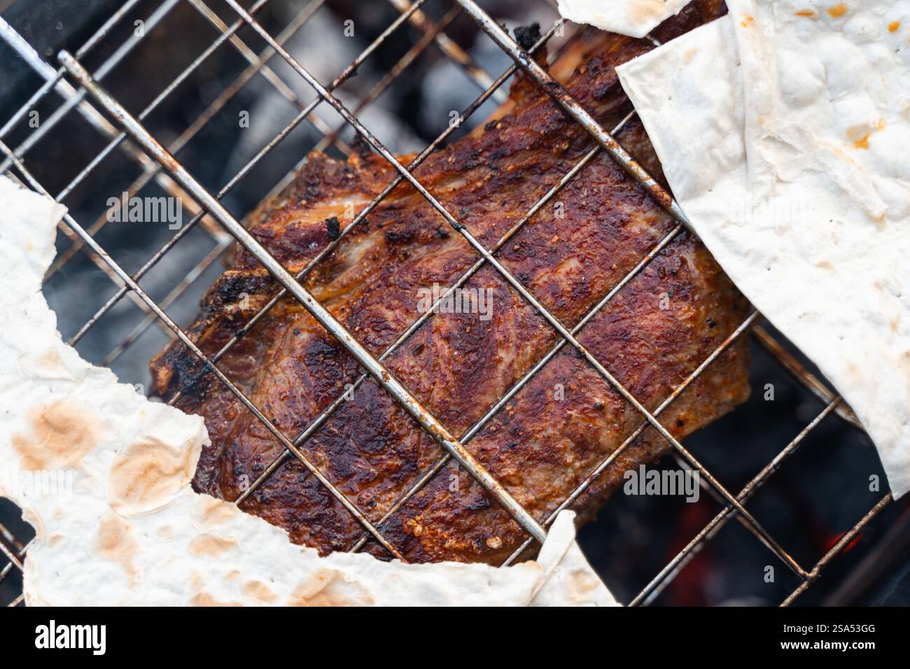 A close-up of perfectly seasoned grilled meat and flatbread on a ...