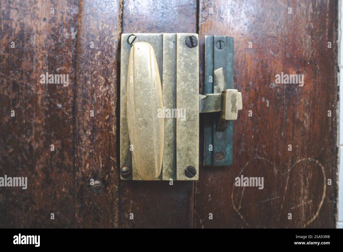 Intricate door latch details on an aged wooden door in a quaint setting ...