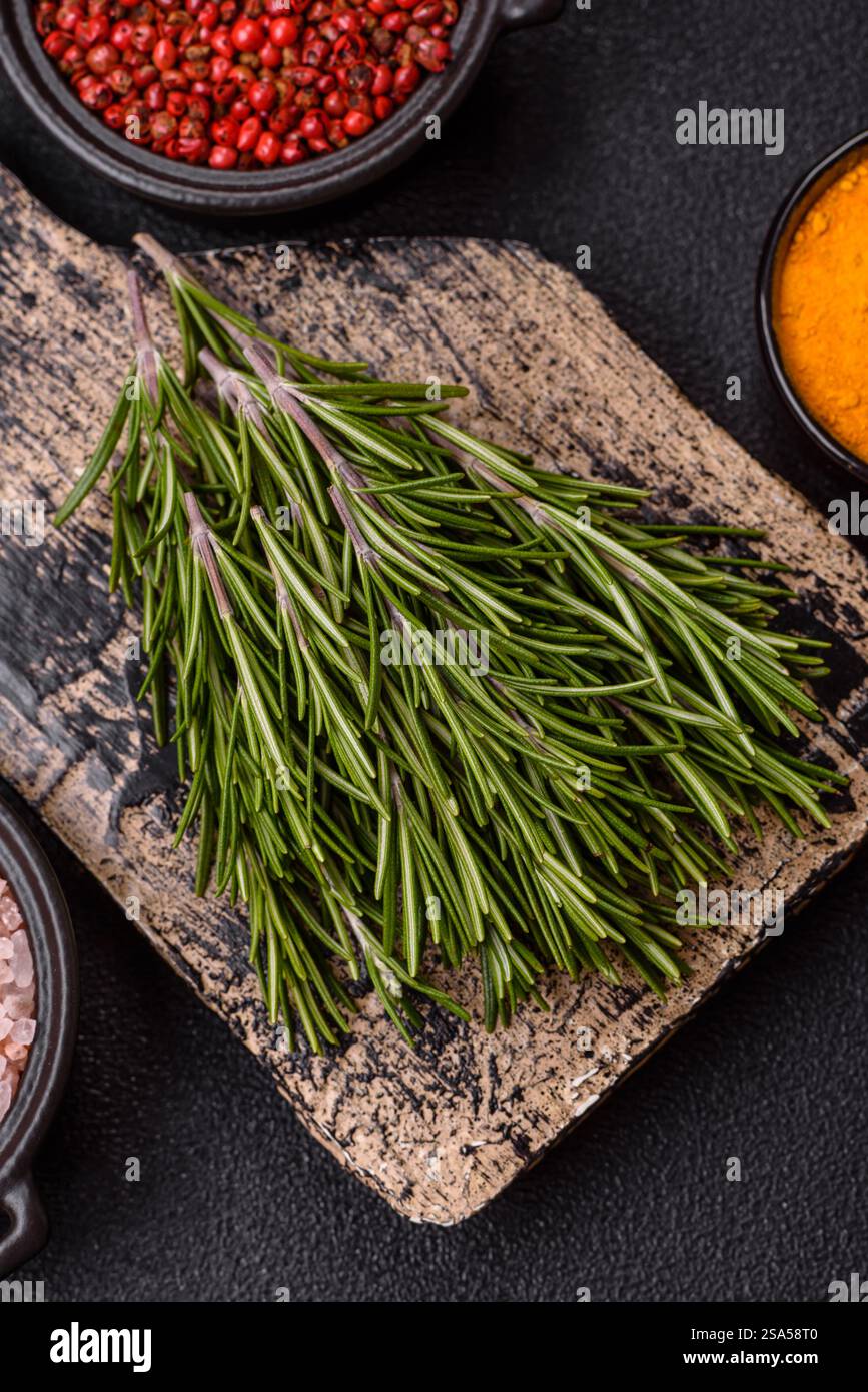 Fresh green rosemary sprigs prepared for cooking, on dark concrete ...