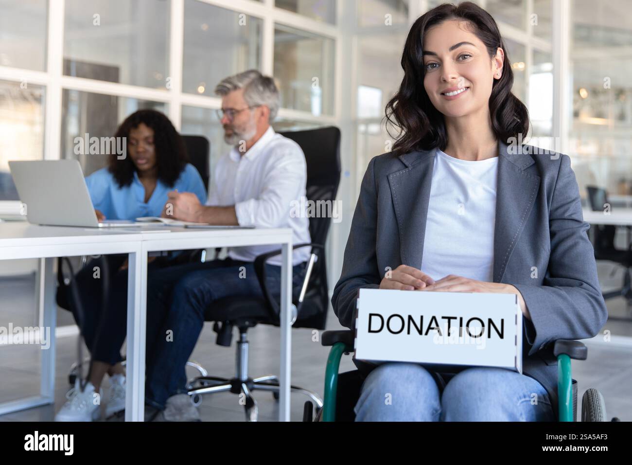 Disabled female worker doing her job in office environment holding box ...