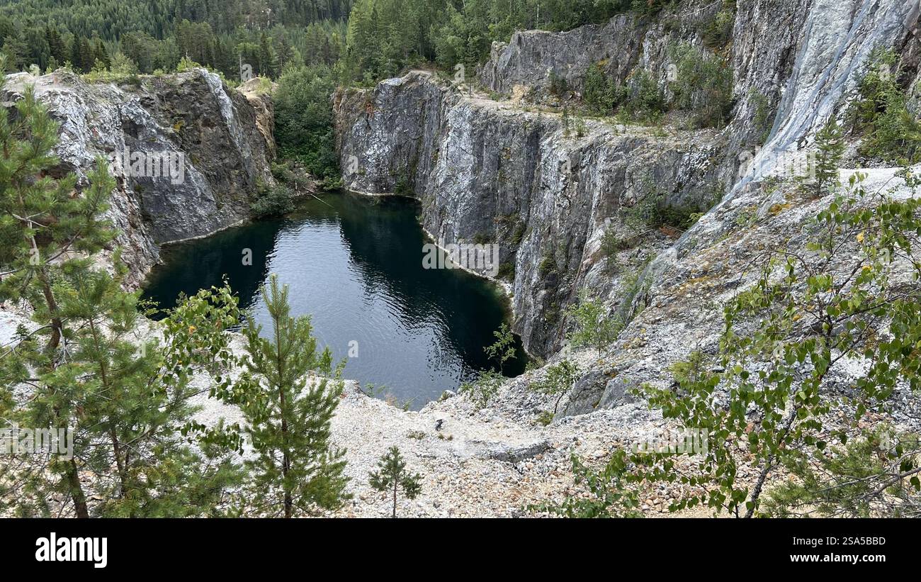 Open pit mine area with a lake, white rocks and trees, pine tree, birch ...
