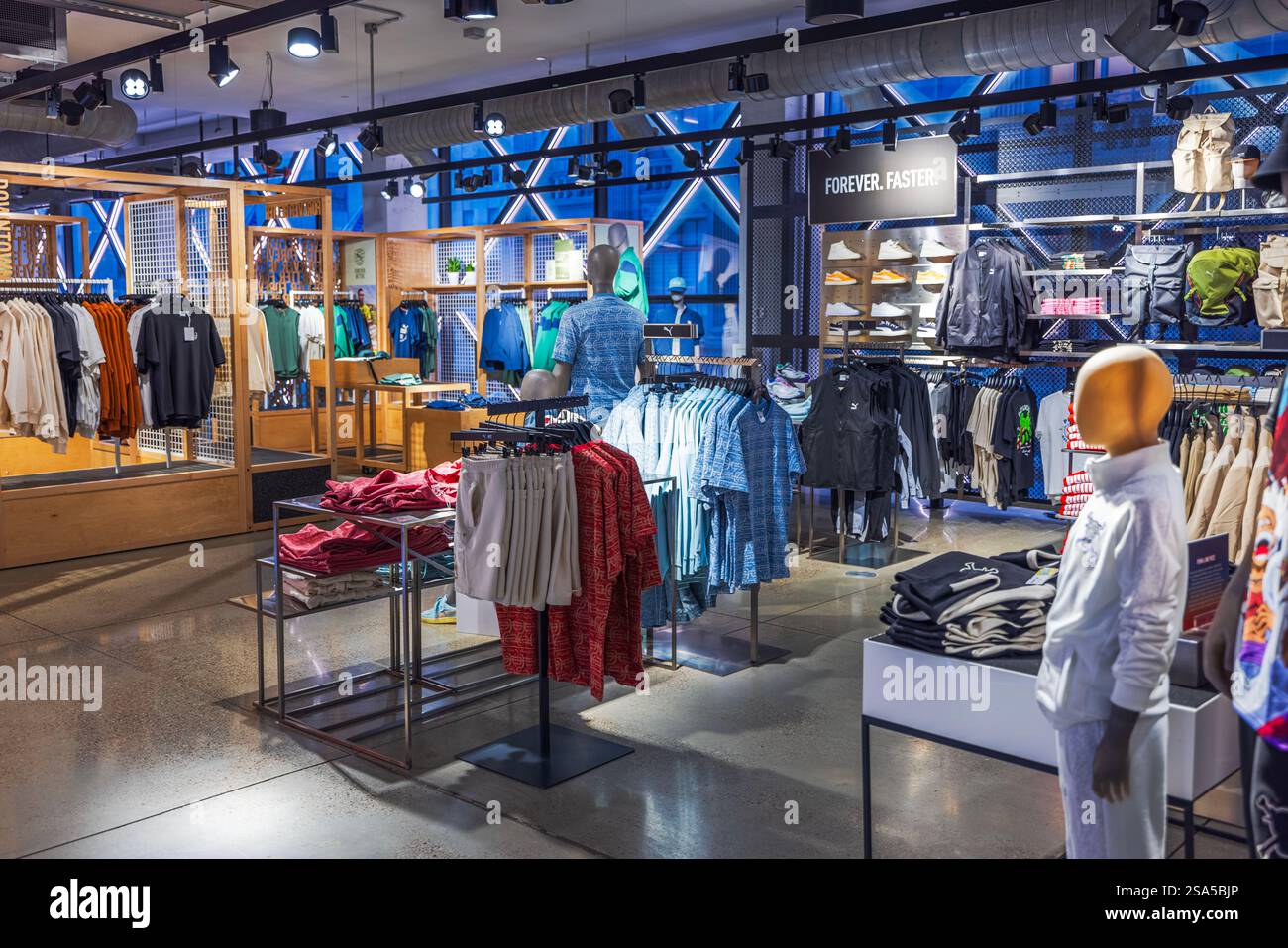 Puma store section displaying men's sportswear with wooden shelves and ...