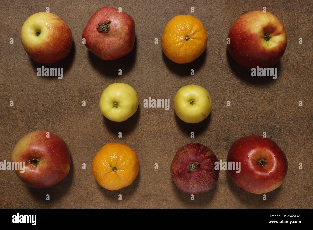 Red and yellow apples, tangerines, pomegranate fruits are laid out ...