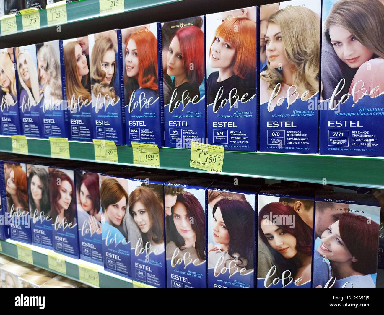Hair dye products display with diverse female models on store shelves ...