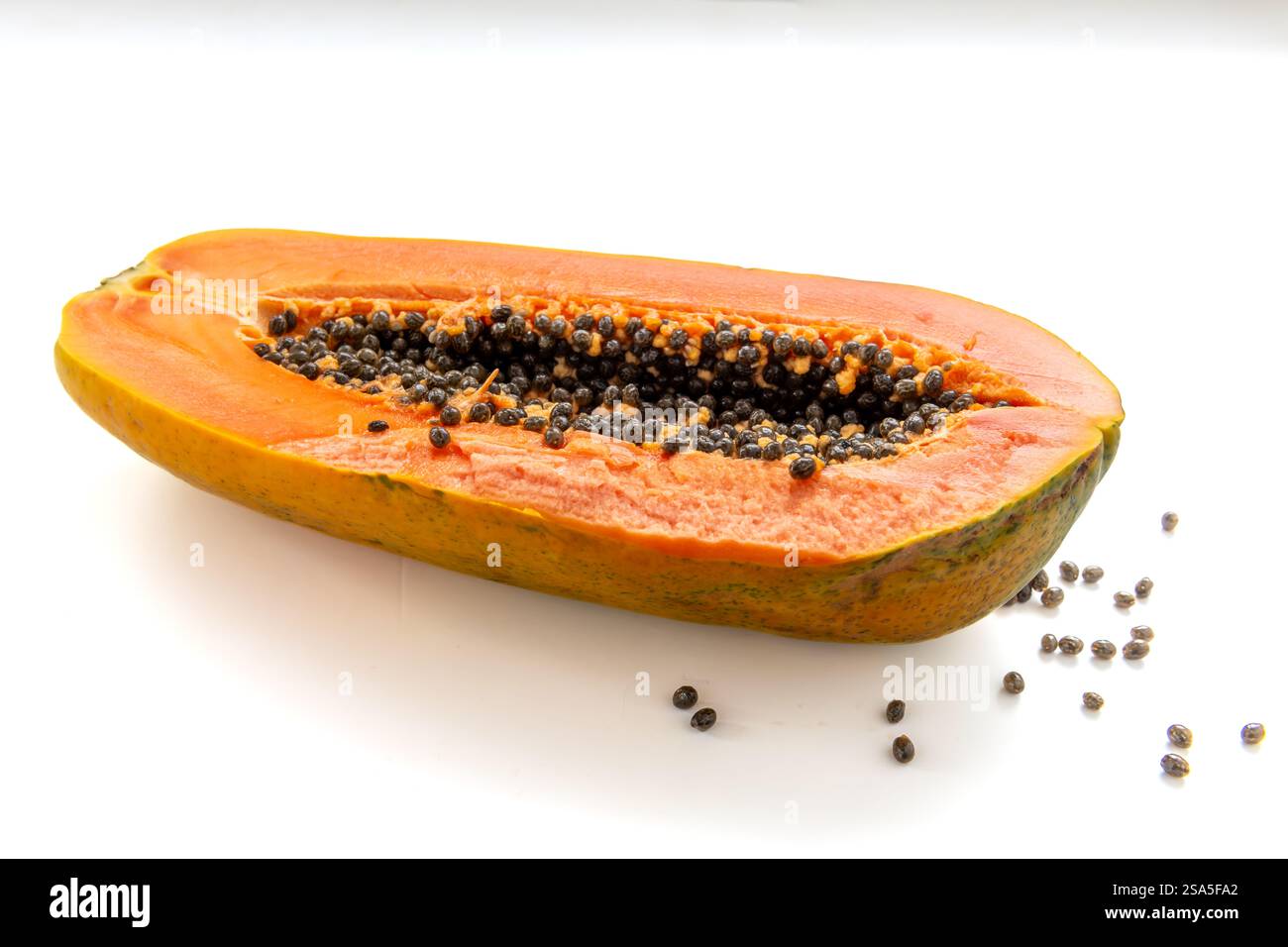 Side view of a half cut papaya showing the orange flesh and black seeds ...