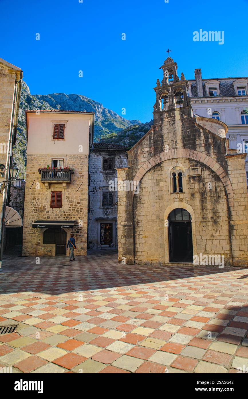Kotor, Montenegro. Person walks on terra cotta checkered cobblestones ...
