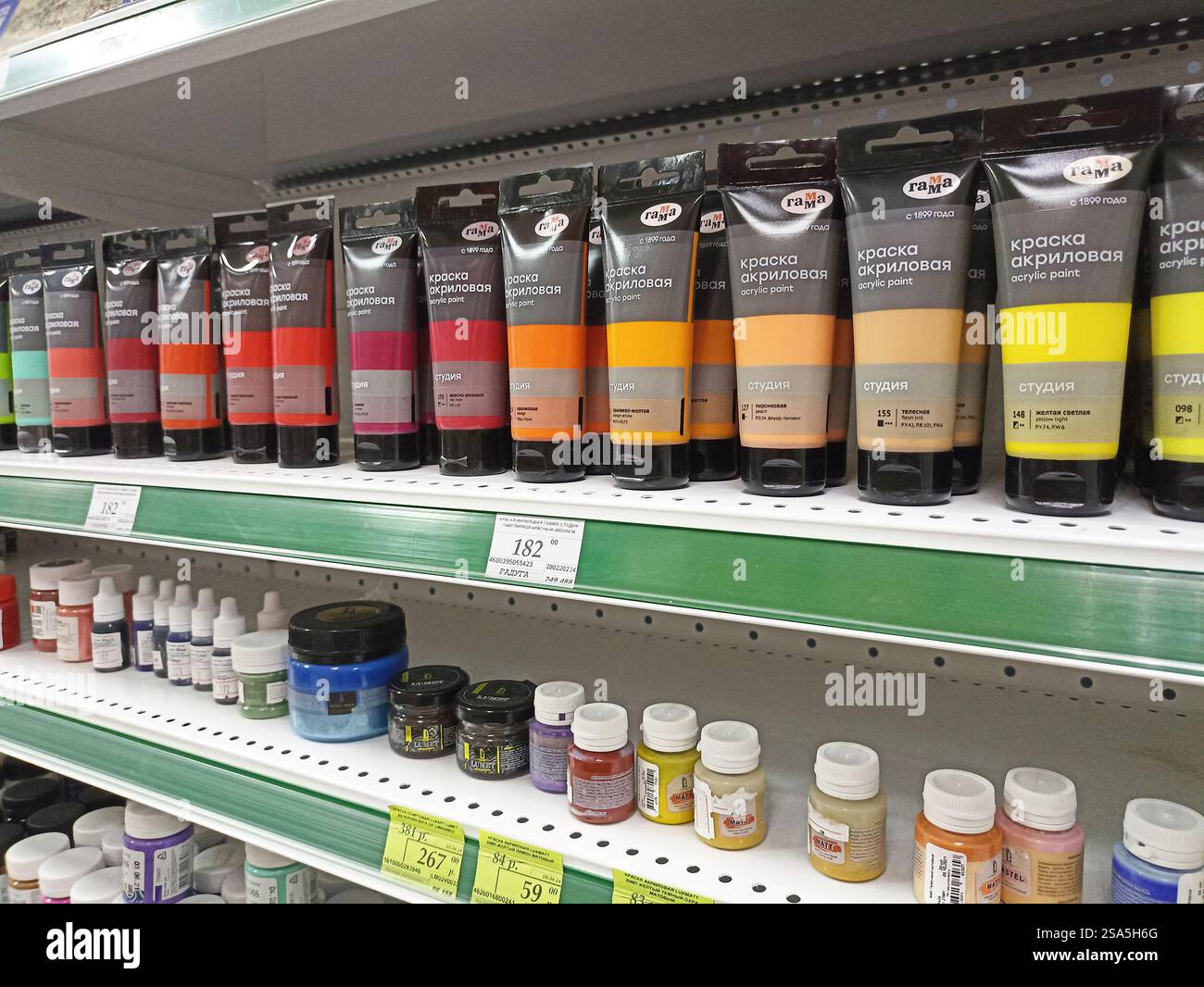 Colorful acrylic paint tubes on store shelves with pricing labels Stock ...