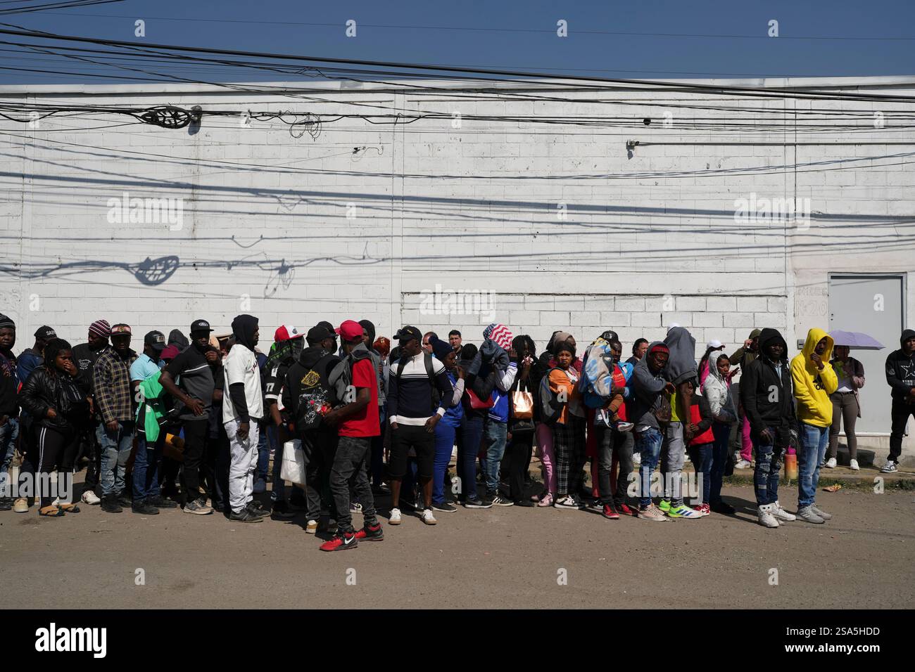 Migrants from Haiti stand in line outside the Mexican Commission for ...
