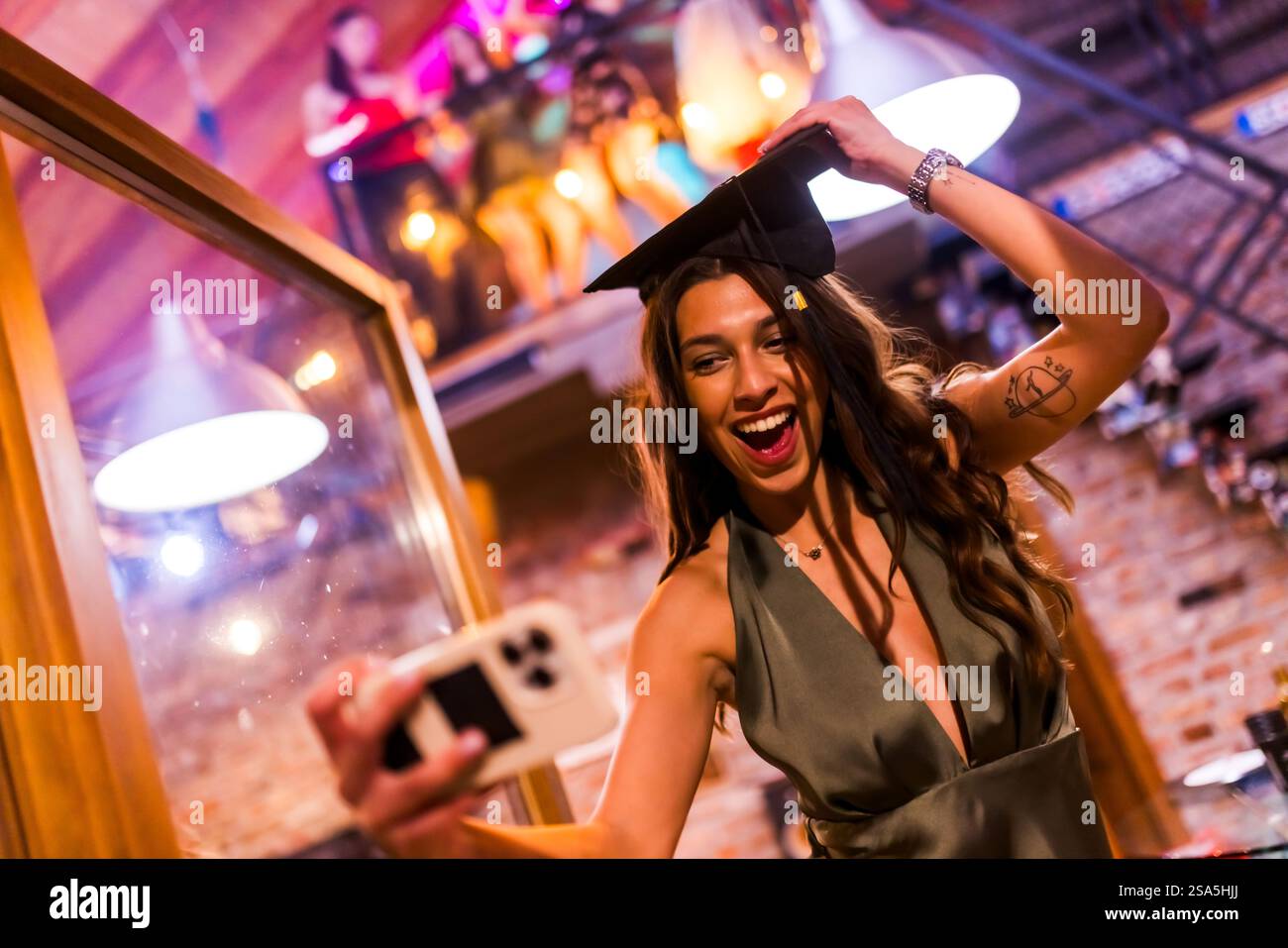 A young woman happily captures a selfie in celebration of her ...