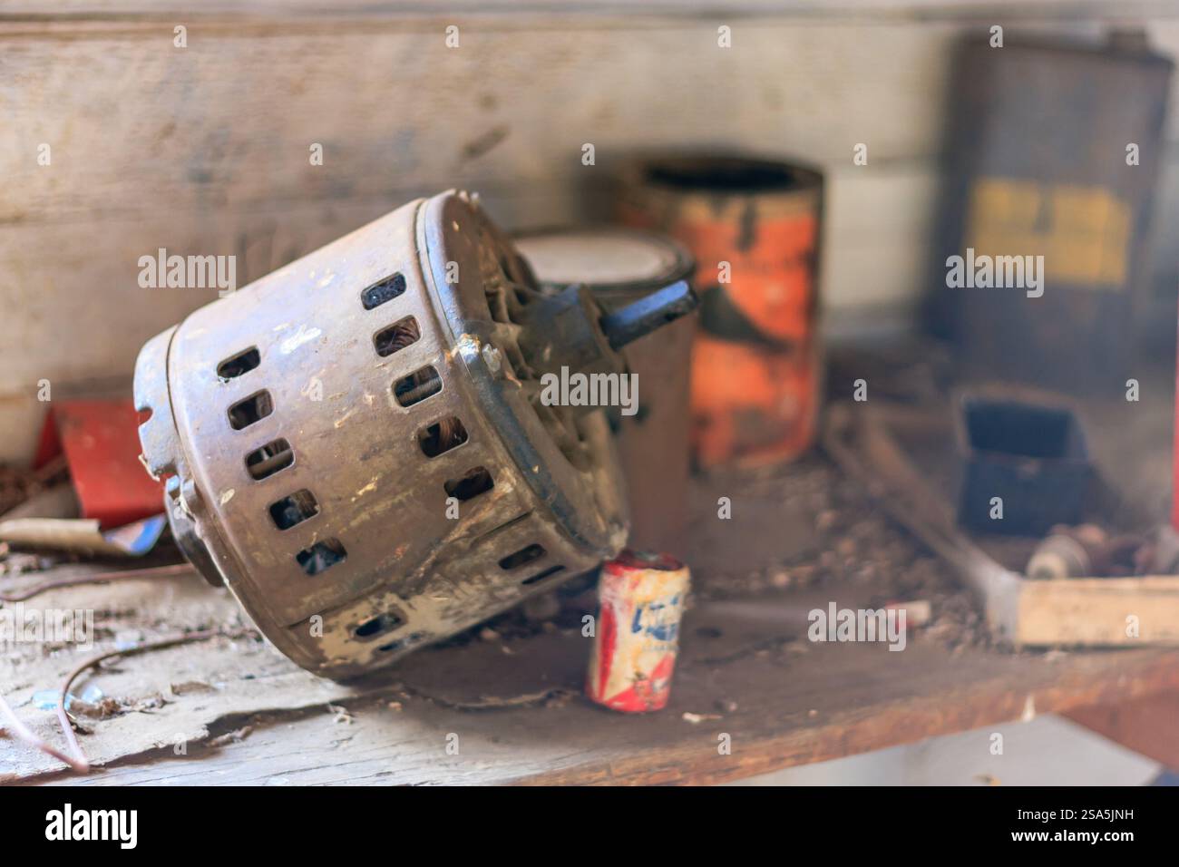 A rusty old machine sits on a table next to a can of Coca-Cola. The ...