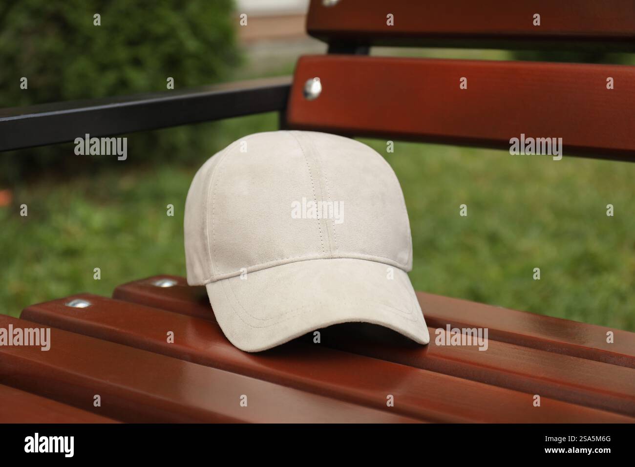 Stylish baseball cap on wooden bench in park. Mockup for design Stock ...