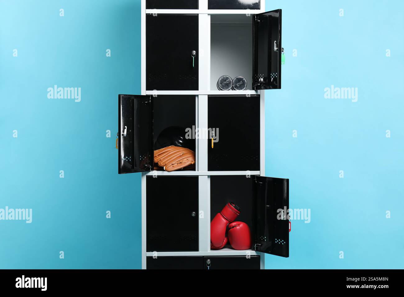 Open lockers with sport equipment on light blue background Stock Photo ...