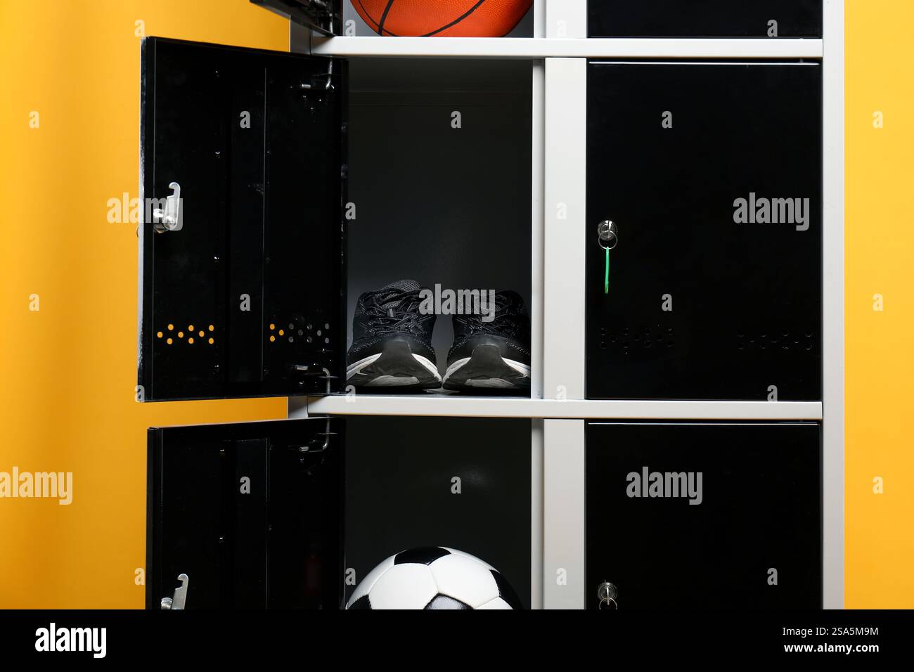 Open lockers with sport equipment on orange background Stock Photo - Alamy