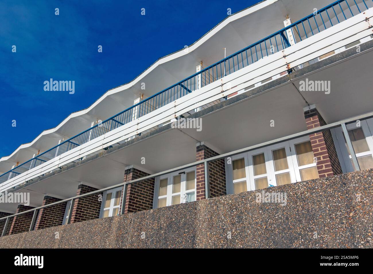 Beach huts line the shore on a sunny Winter's day at Branksome Chine ...