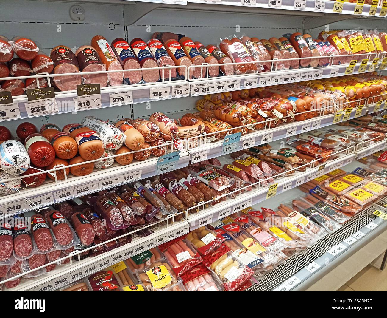 Assortment of packaged sausages on supermarket shelf display Stock ...