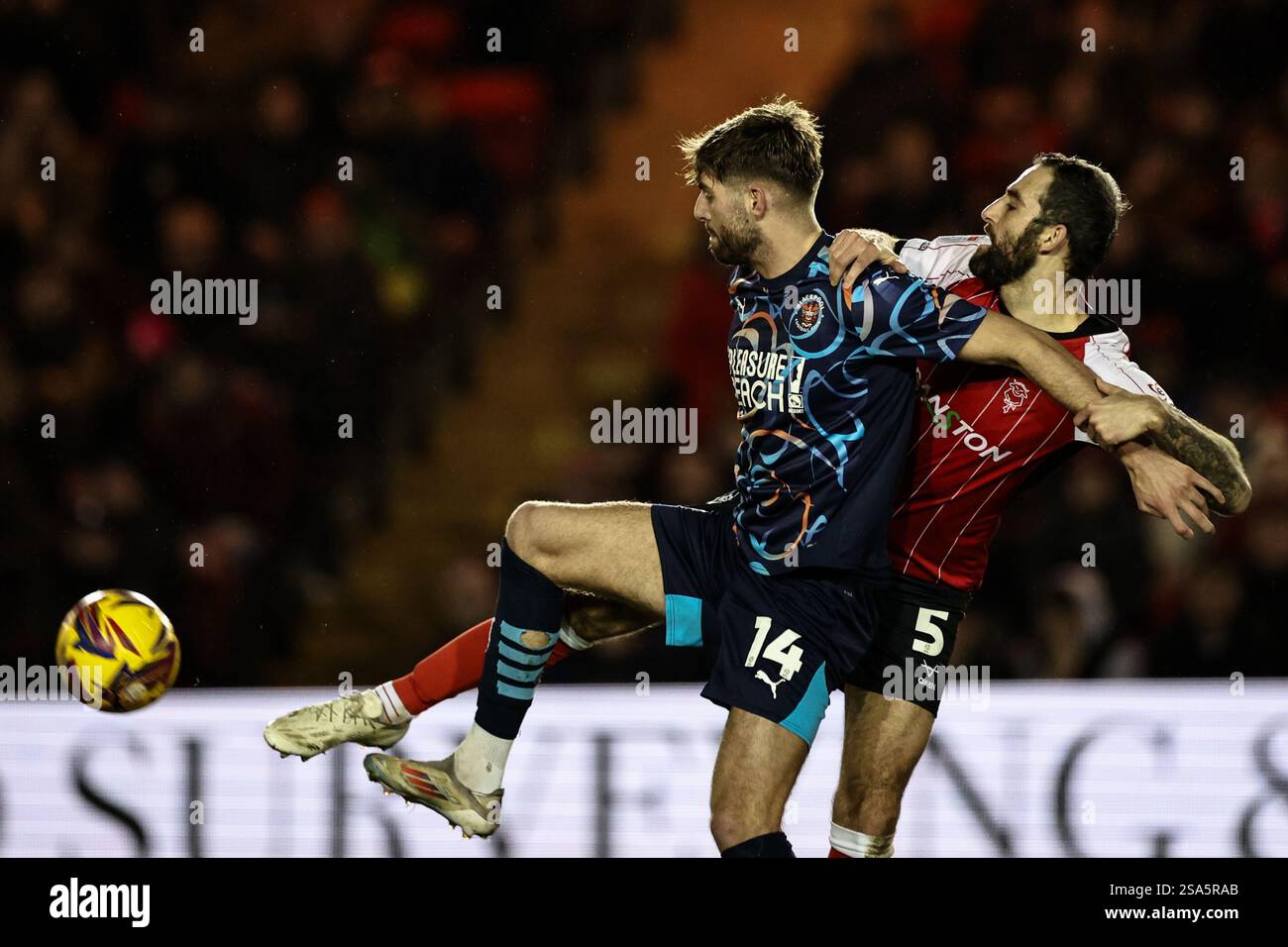 Tom Bloxham of Blackpool holds off Adam Jackson of Lincoln City during ...