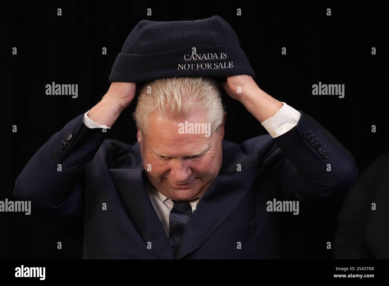 Ontario Premier Doug Ford pulls on a toque following a press conference ...