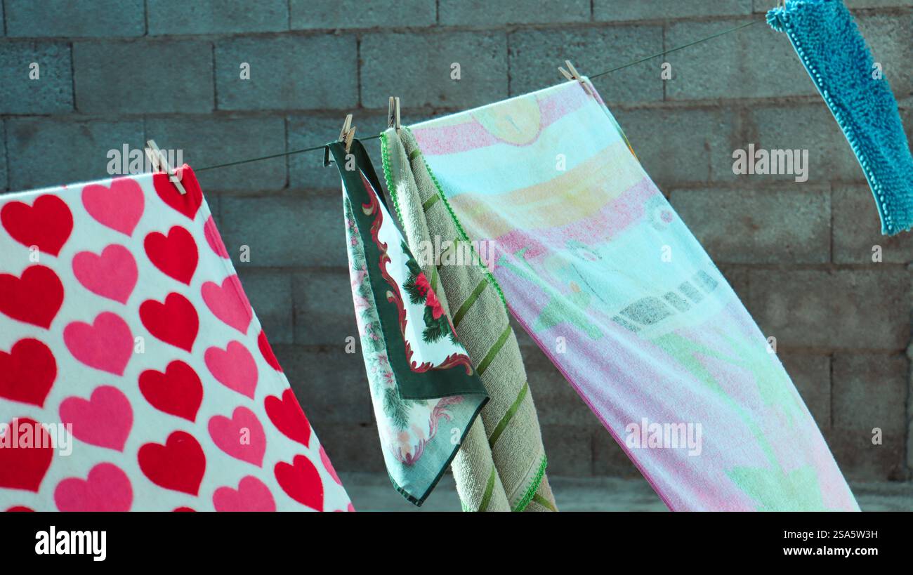 Clothes on a clothesline drying in the sun, including a blanket with ...