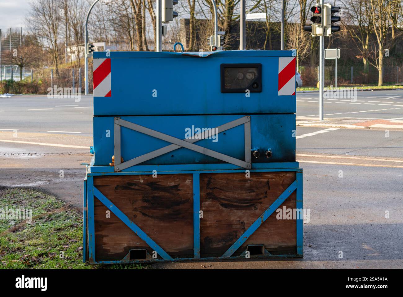 A blue utility box is positioned next to an intersection, equipped with ...