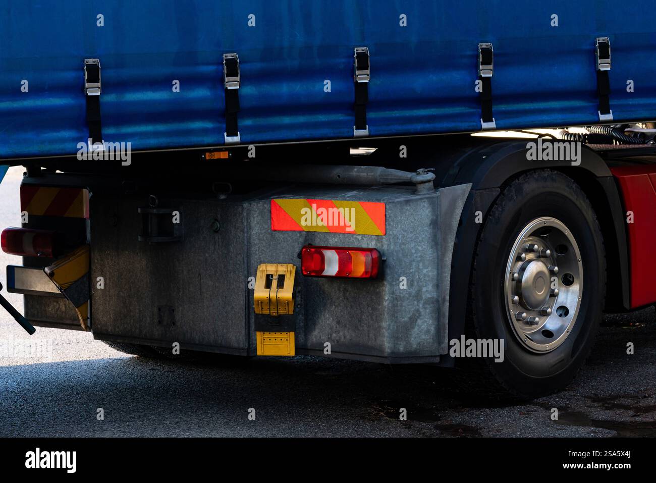 Rear view of wheel and brake light of large truck parked at a loading ...