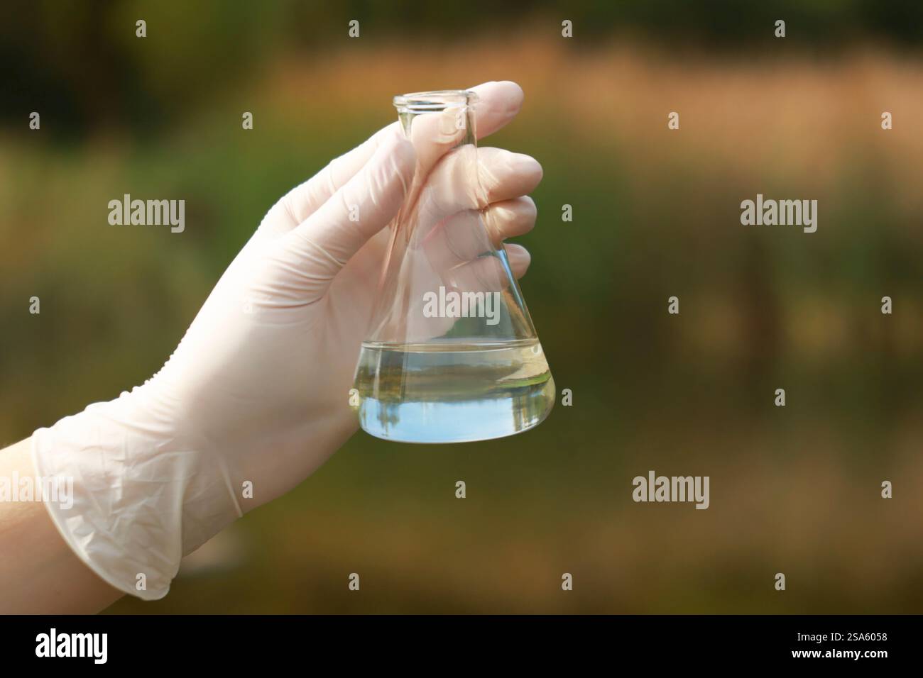 Examination of water quality. Researcher holding flask with sample ...