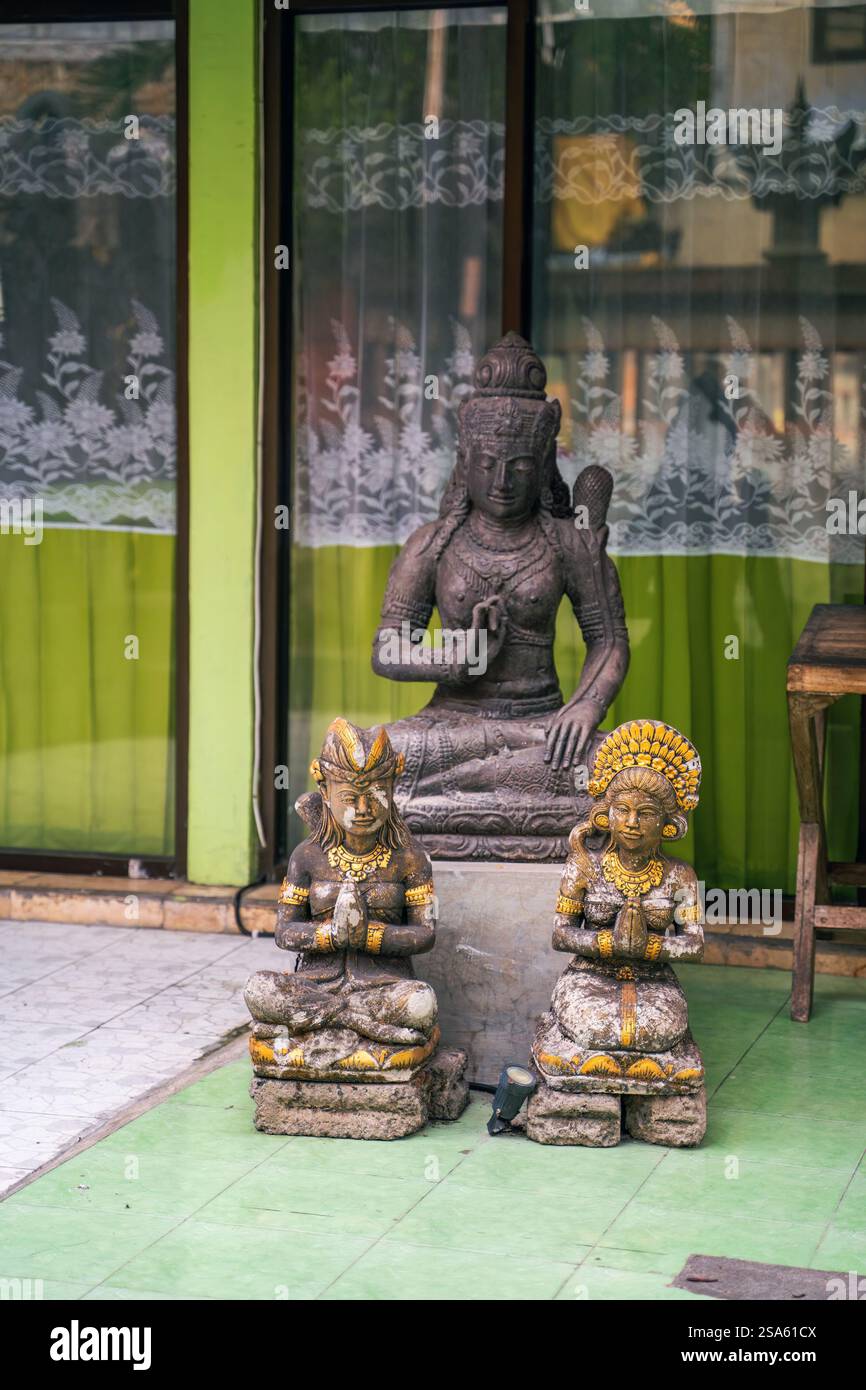 Three serene Balinese statues, adorned with intricate details and rich ...