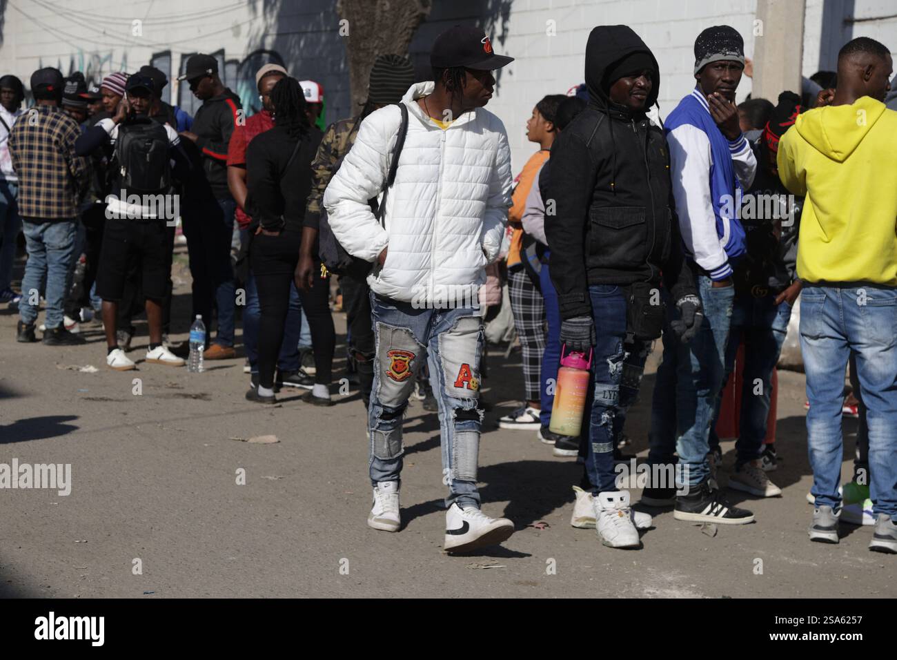 Haitian, Cuban and Venezuelan migrants wait outside the Mexican ...