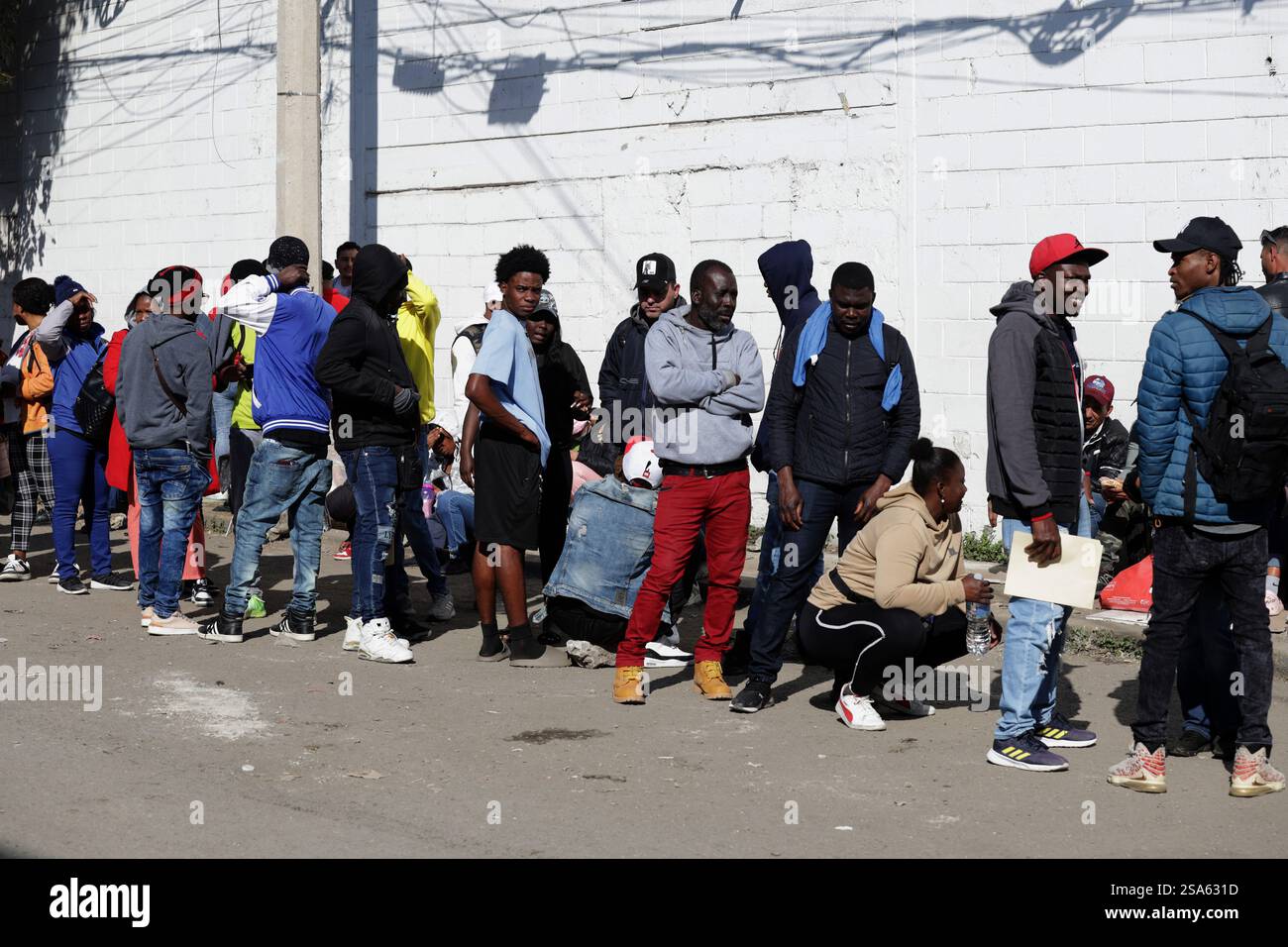Haitian, Cuban and Venezuelan migrants wait outside the Mexican ...