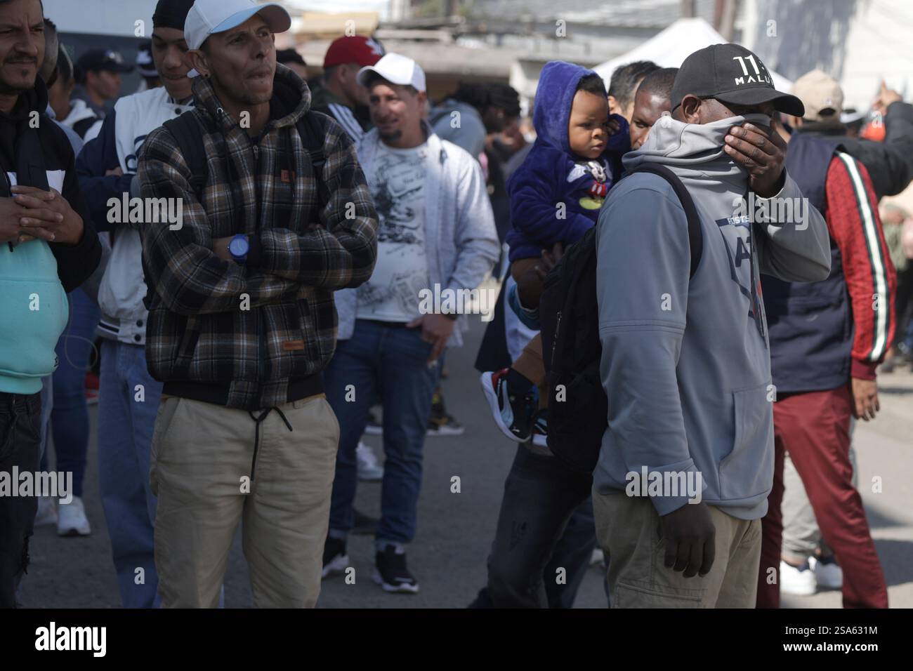 Haitian, Cuban and Venezuelan migrants wait outside the Mexican ...