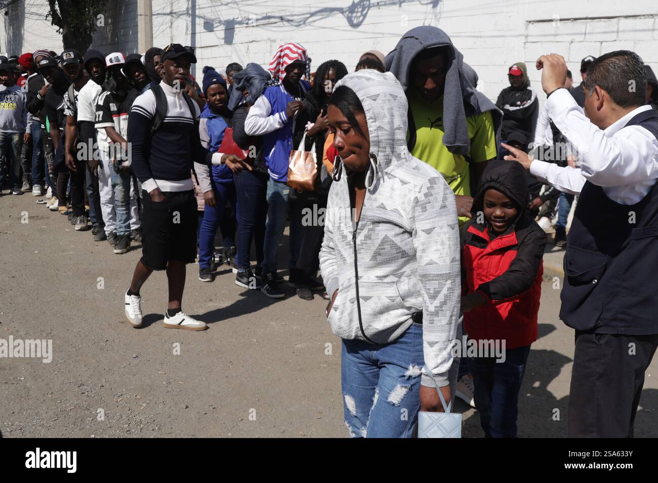 Haitian, Cuban and Venezuelan migrants wait outside the Mexican ...