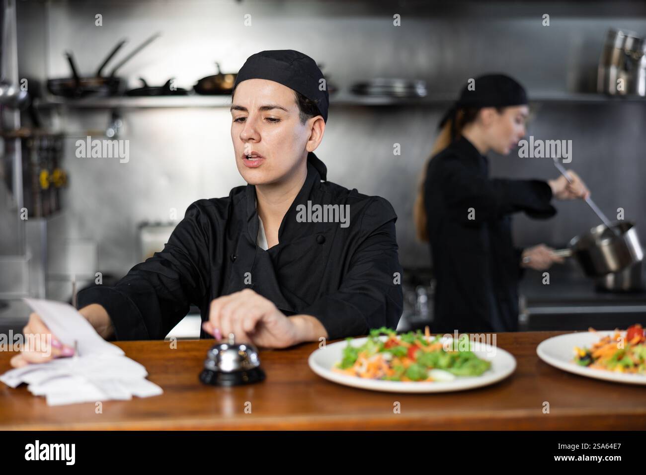 Chef checking orders and giving out meal Stock Photo - Alamy