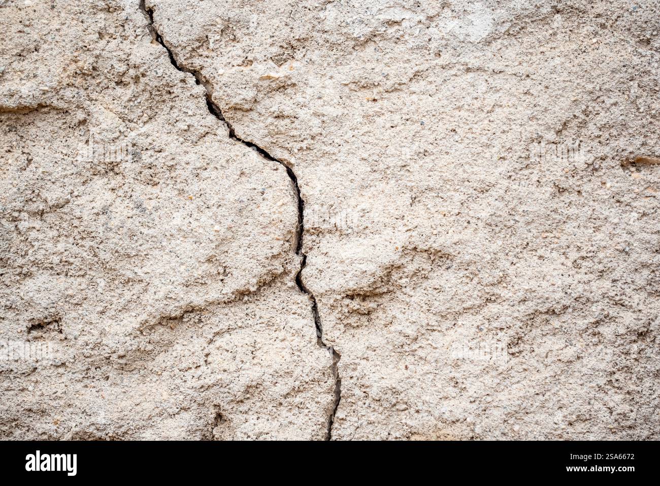 A wall with a crack in it. The crack is long and deep. The wall is made ...