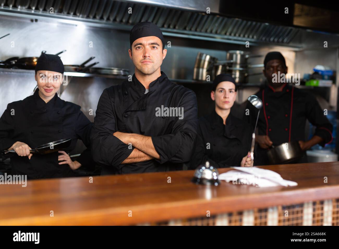 Team of chefs posing in restaurant kitchen Stock Photo - Alamy