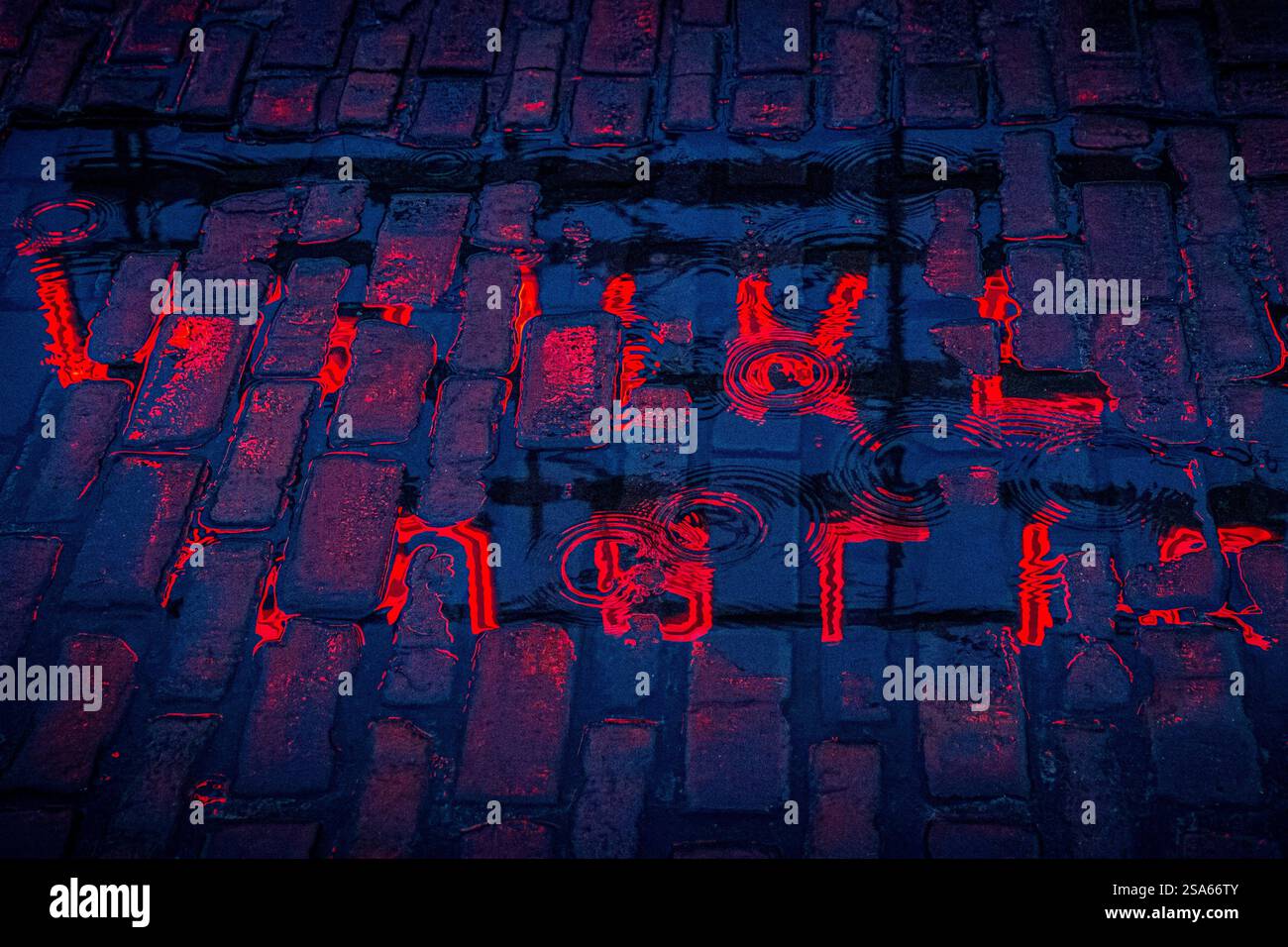 An abstract reflection of vibrant red neon light rippling in rain ...