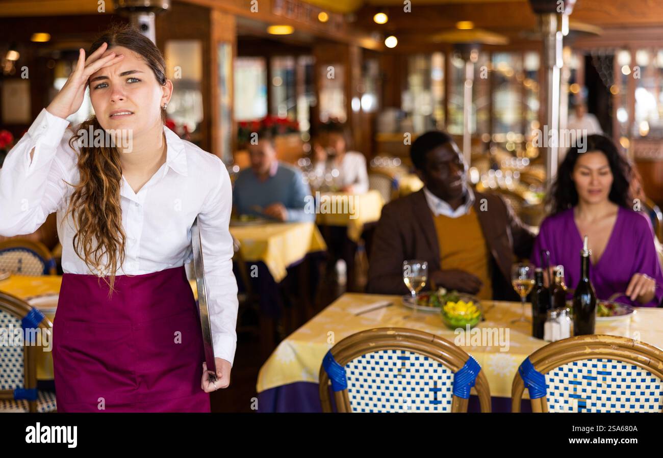 Portrait of tired upset waitress in the hall of restaurant Stock Photo ...