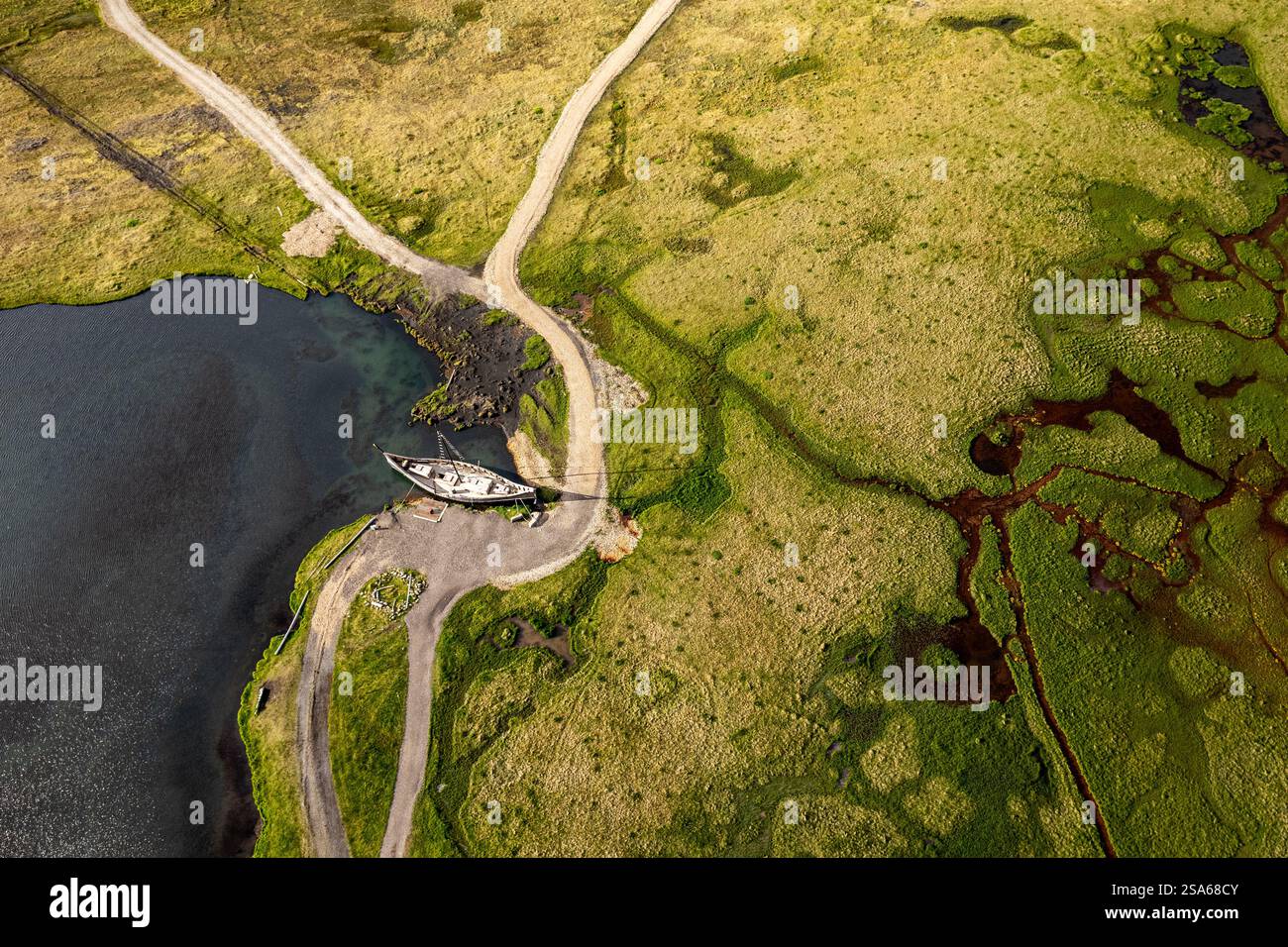 Aerial drone view of lone viking boat docked in serene green landscape ...