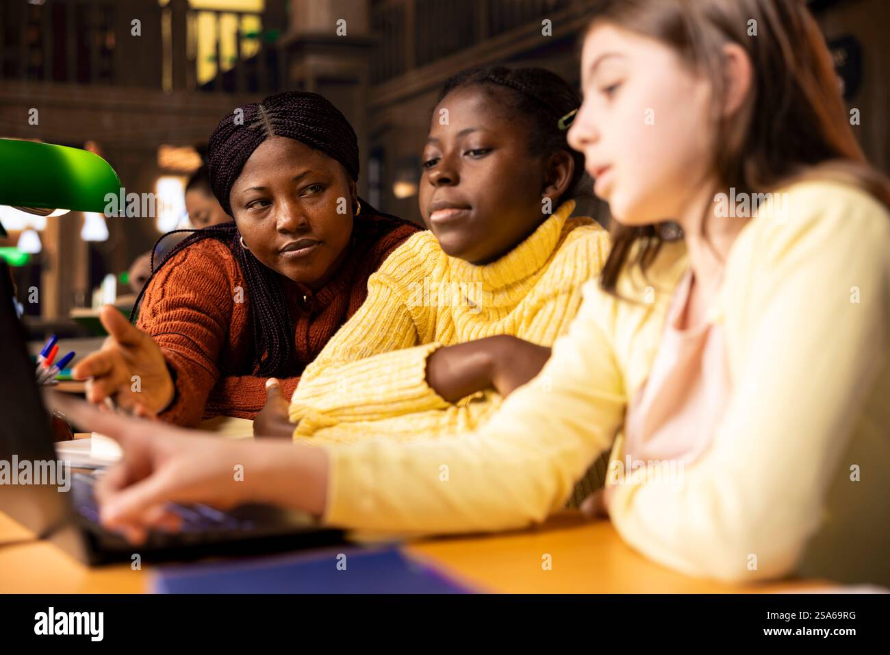 Elementary school professor engaging with girls students during private ...