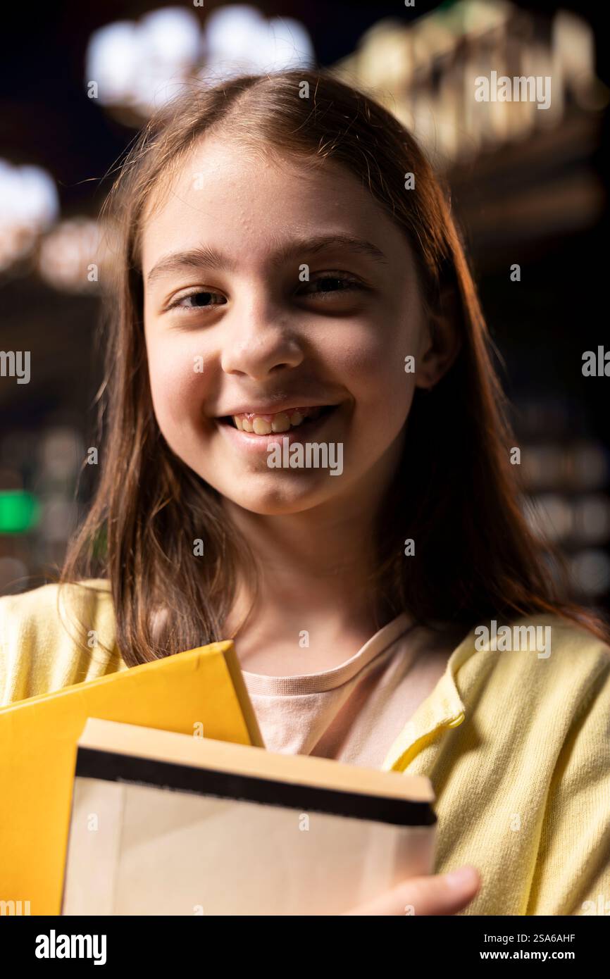 Portrait of adolescent pupil girl studying at the public library ...