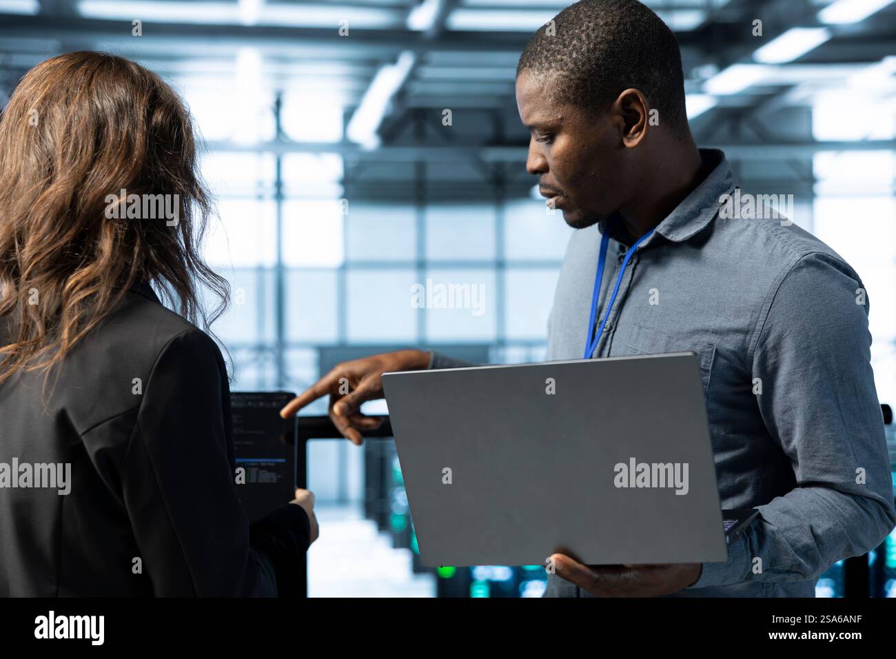 Colleagues in data center workspace use laptop to calibrate energy ...